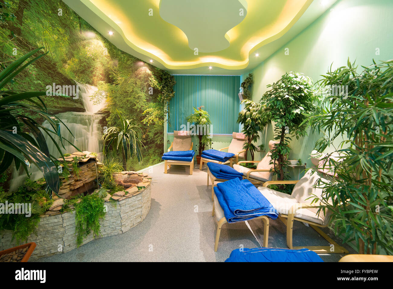 Relax area interior with green trees and small waterfall Stock Photo ...