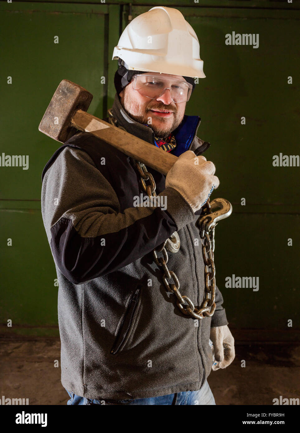 Tough worker in safety helmet with iron chain and sledgehammer Stock ...