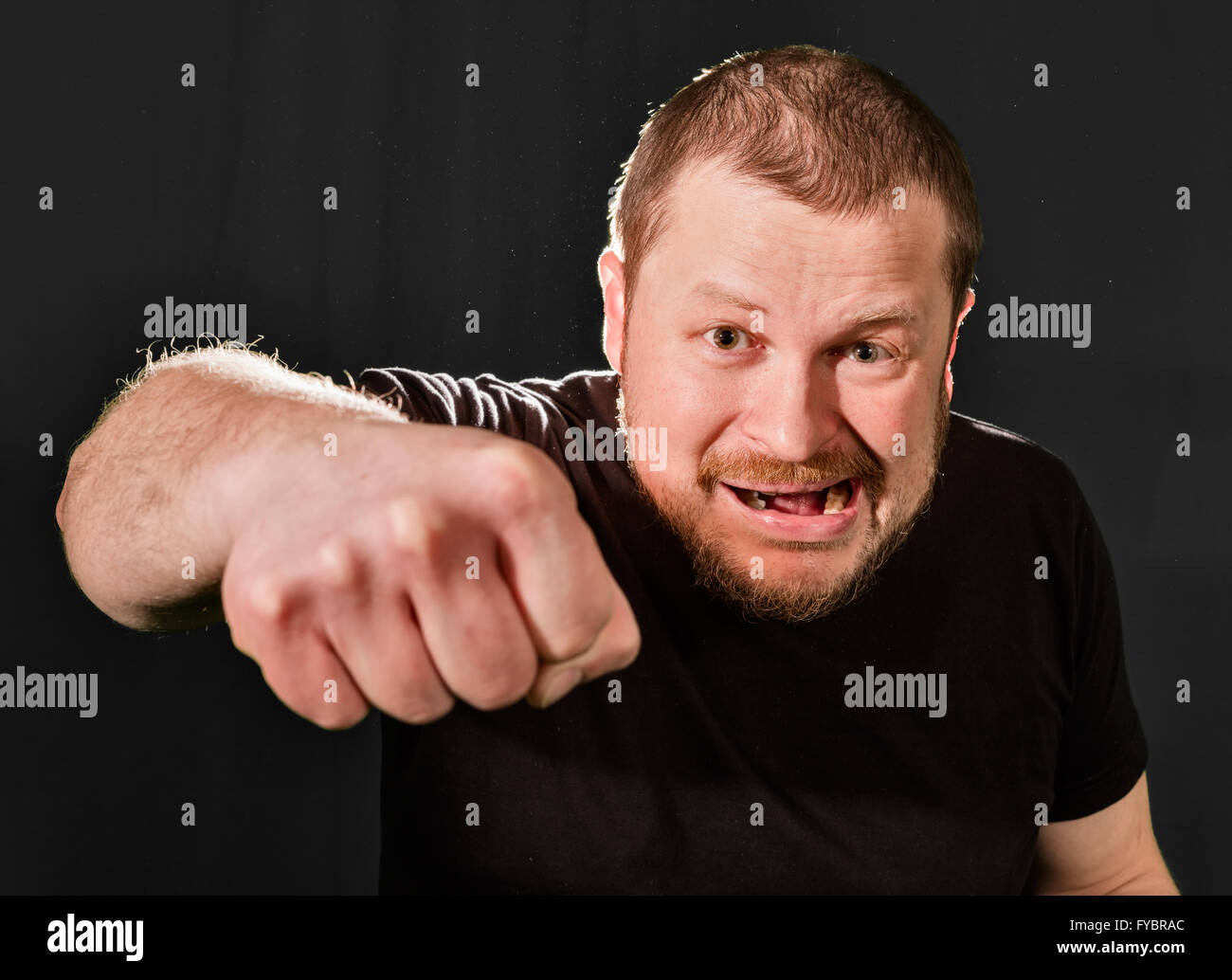 Aggressive bully threatens with a fist portrait low key Stock Photo - Alamy