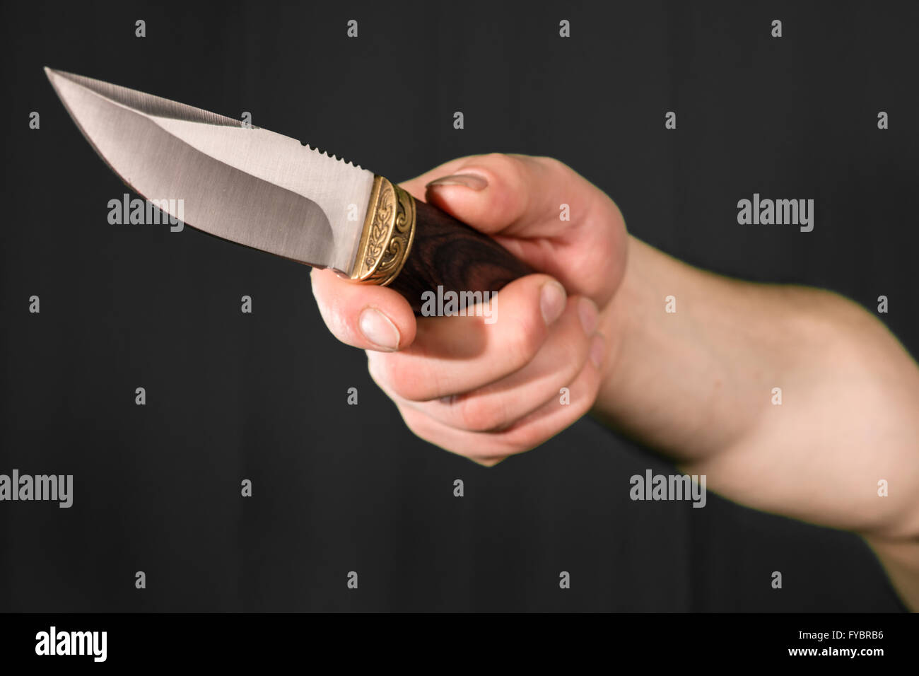Man's hand holding knife close up view on black background Stock Photo ...