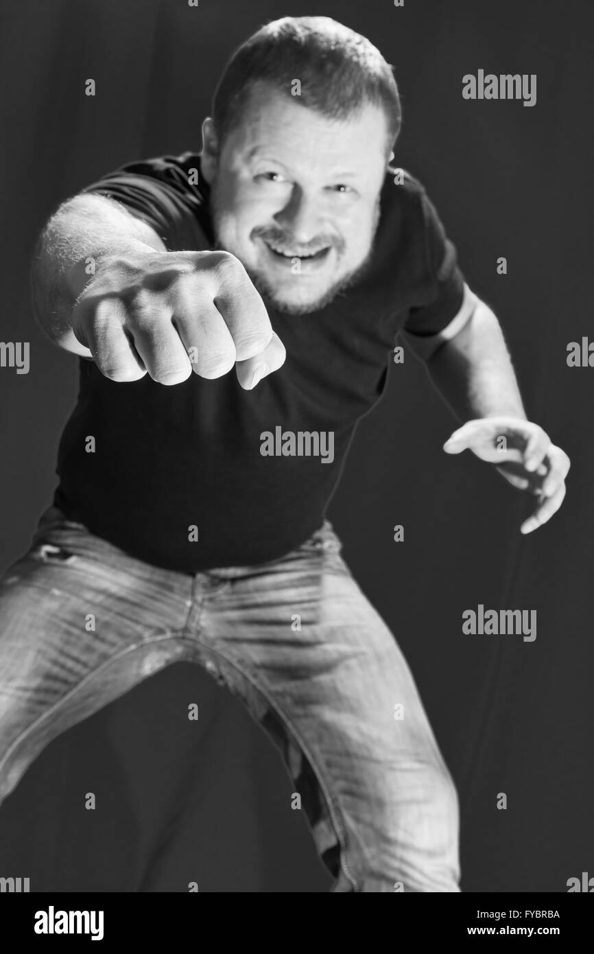 Emotional portrait of agressive bully fighting on black background ...