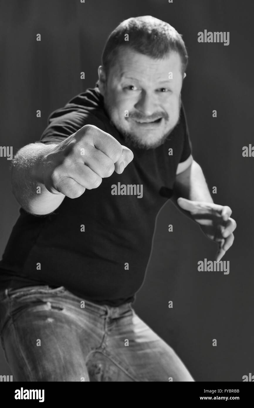 Emotional portrait of agressive bully fighting on black background ...