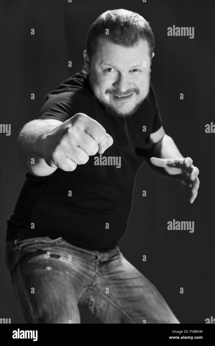 Emotional portrait of agressive bully fighting on black background ...