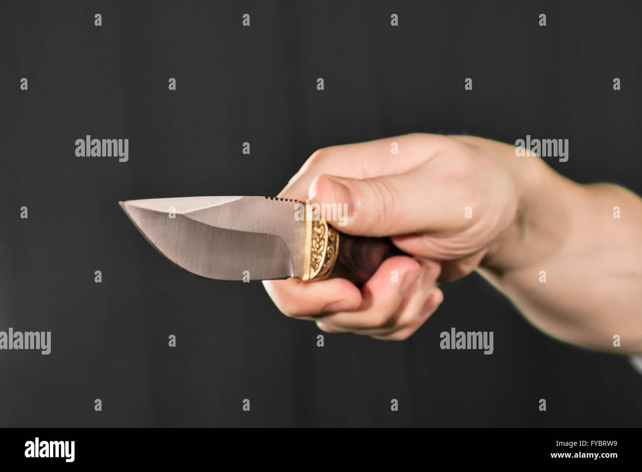 Man's hand holding knife close up view on black background Stock Photo ...