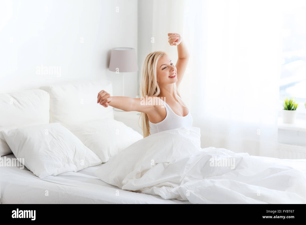 young woman stretching in bed after waking up Stock Photo - Alamy