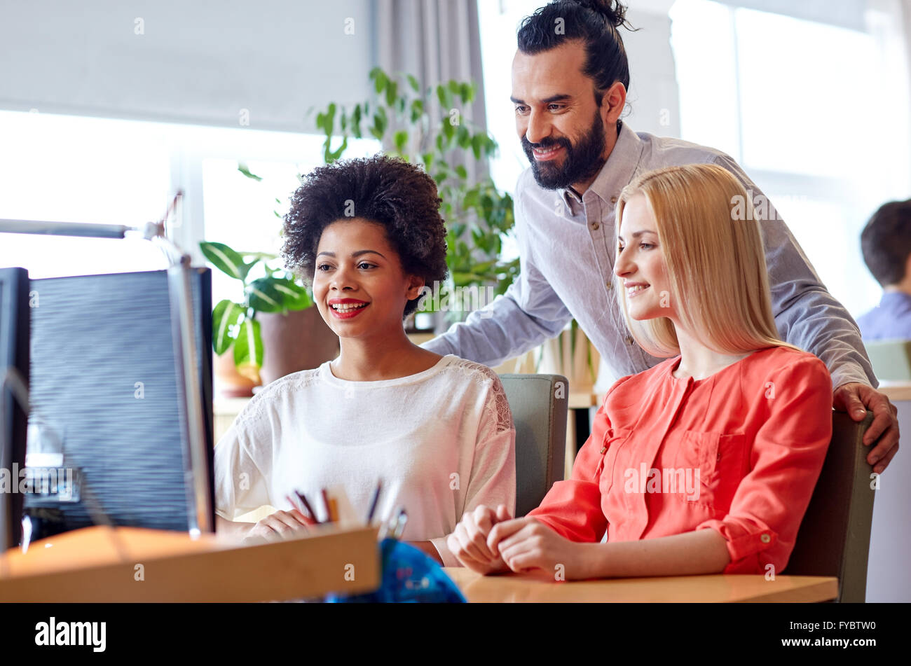 happy creative team with computer in office Stock Photo - Alamy
