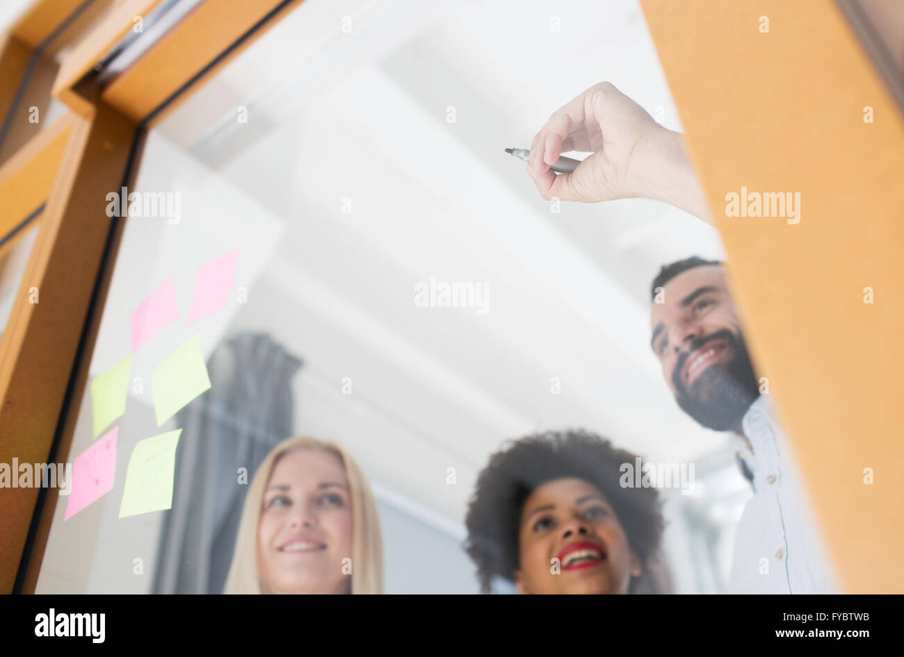 happy creative team writing on blank office glass Stock Photo - Alamy