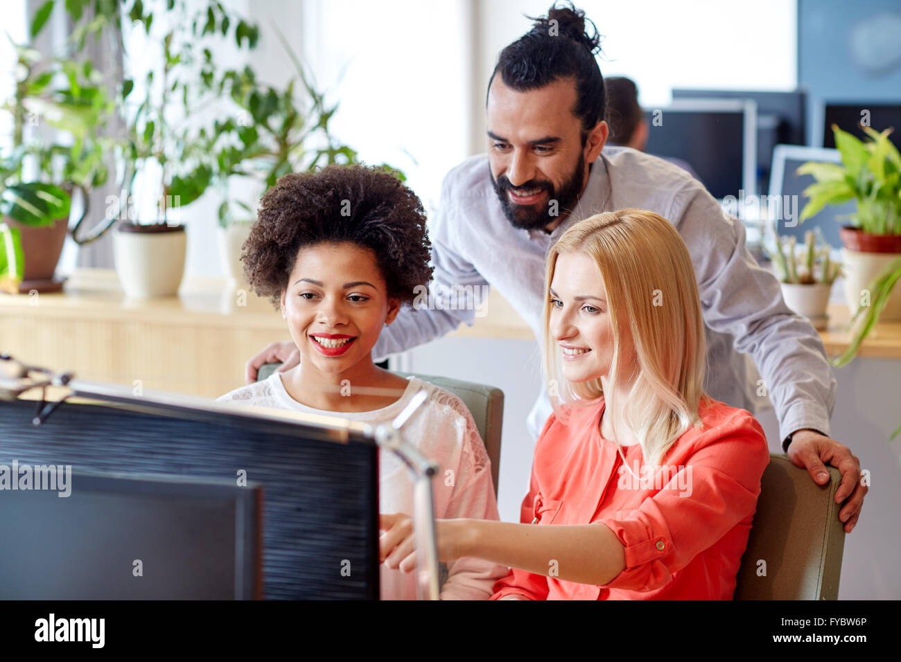 happy creative team with computer in office Stock Photo - Alamy