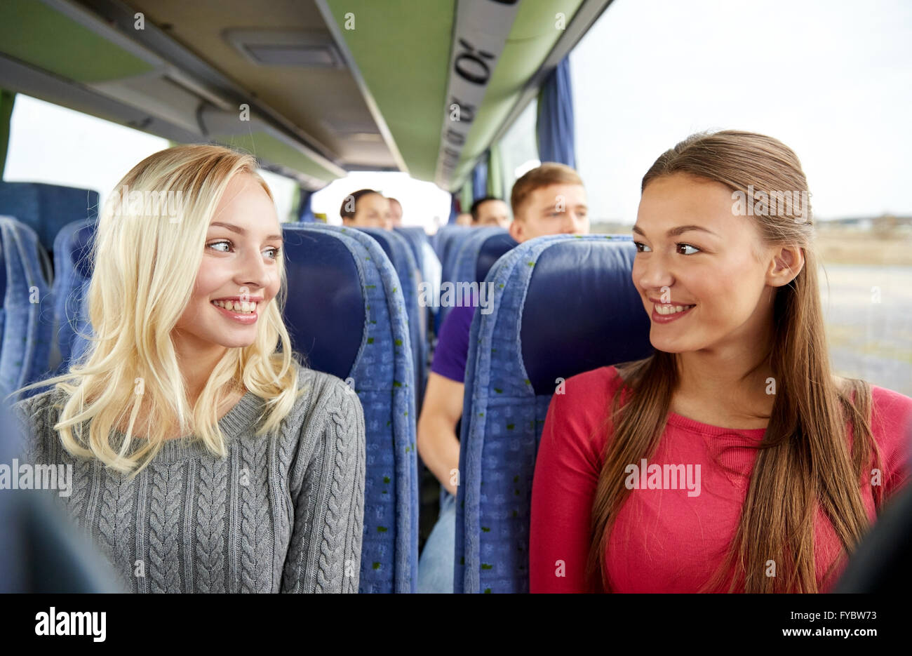 happy young women talking in travel bus Stock Photo - Alamy