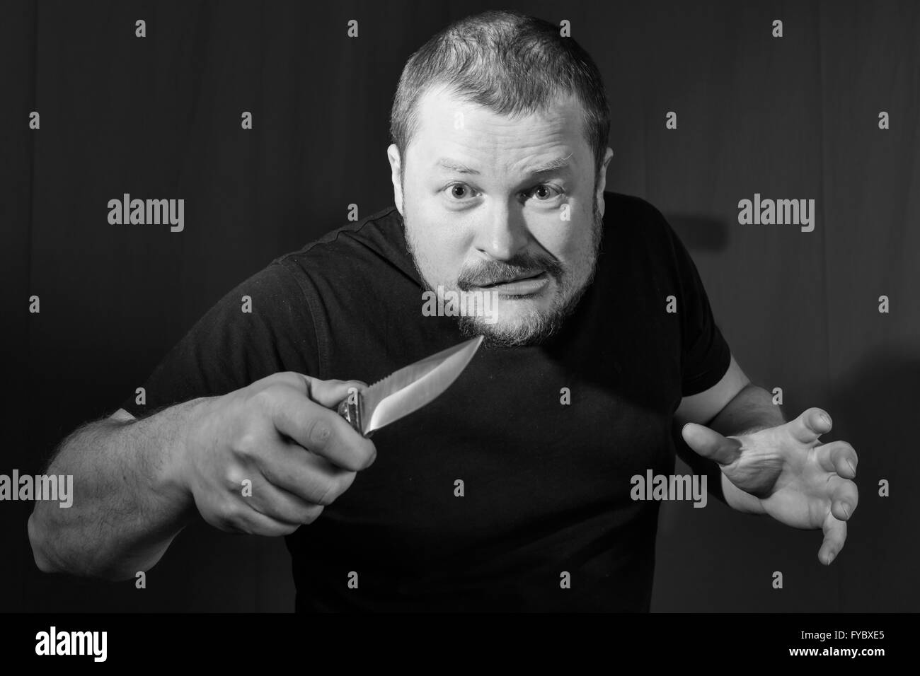 Portrait of a gangster with a knife low key Stock Photo - Alamy