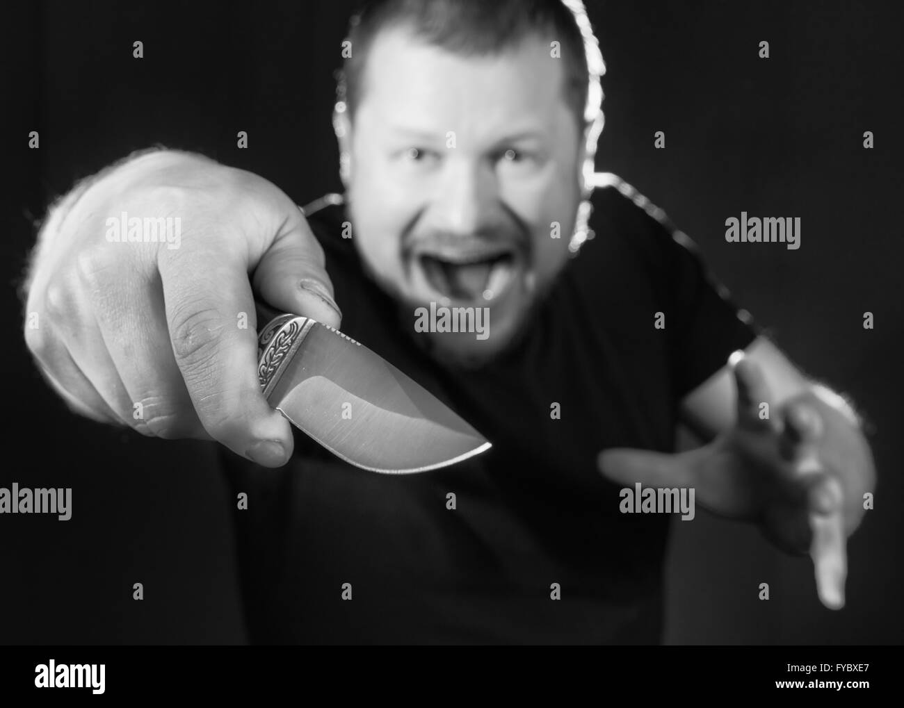 Portrait of a gangster with a knife low key Stock Photo - Alamy