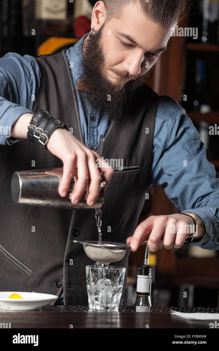 Barman makes cocktails with the help of a shaker Stock Photo - Alamy