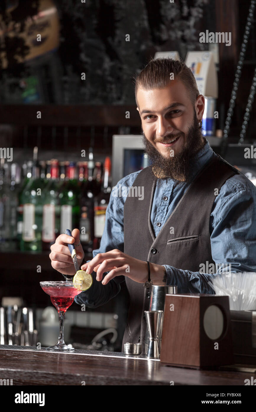 Happy young barman serving cocktail at the bar Stock Photo - Alamy
