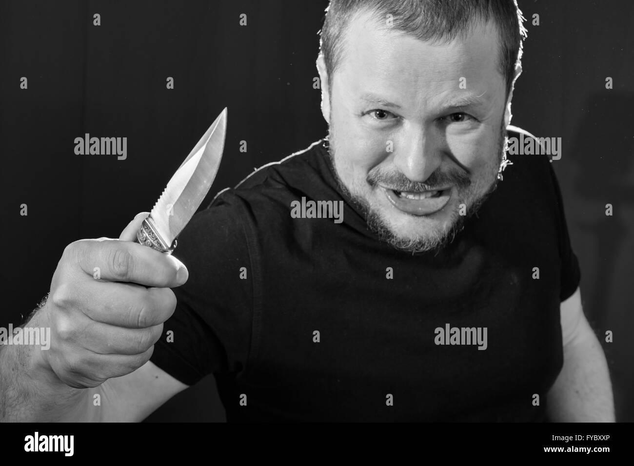 Portrait of a gangster with a knife low key Stock Photo - Alamy