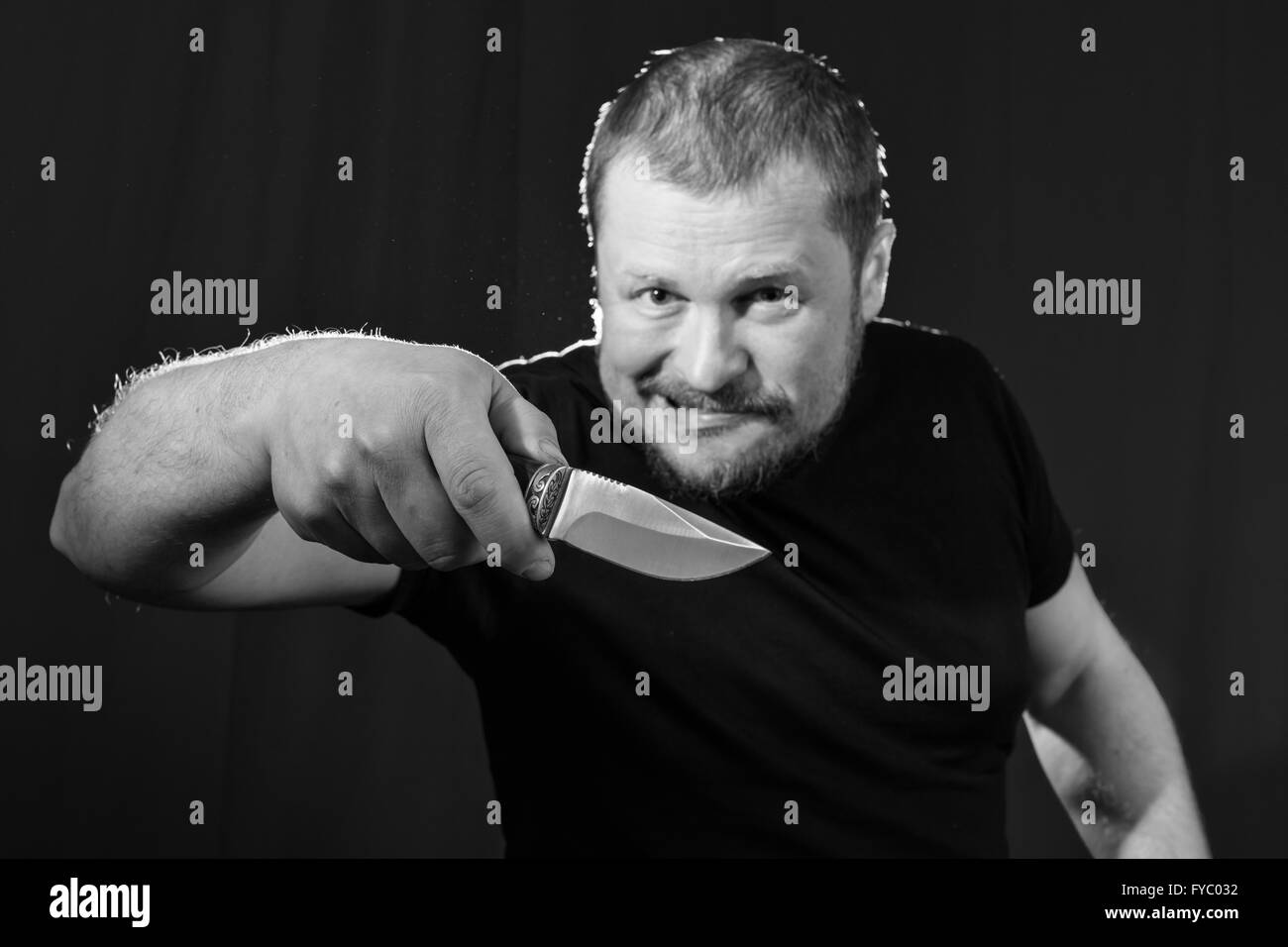 Portrait of a gangster with a knife low key Stock Photo - Alamy