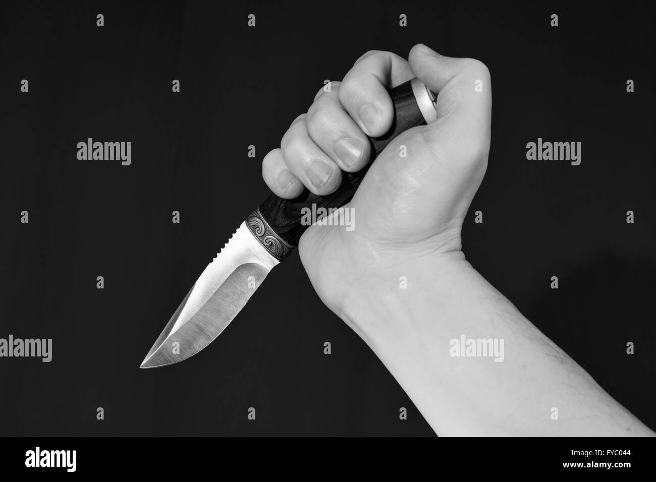 Man's hand holding knife close up view on black background Stock Photo ...
