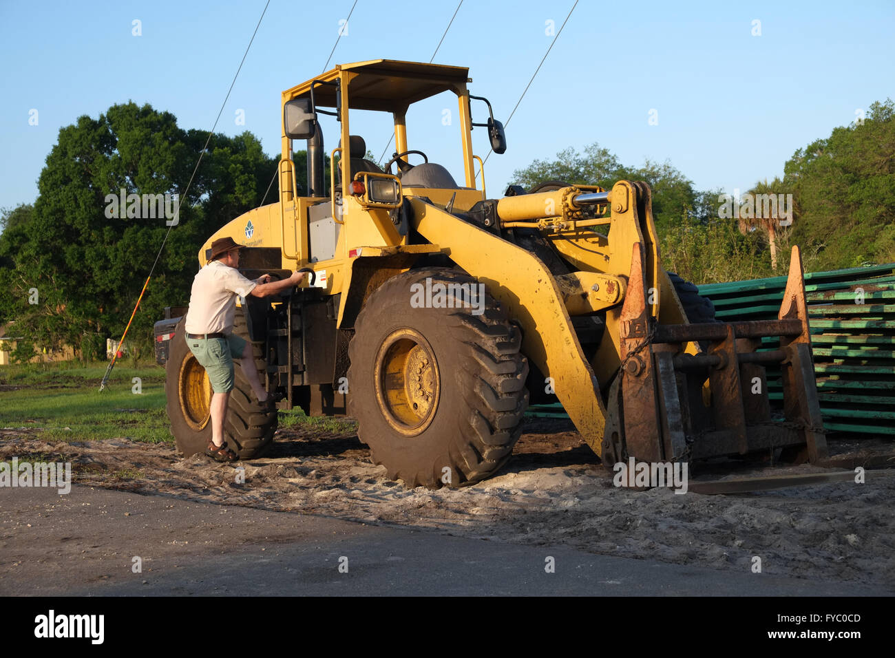 A mature guy and his big yellow construction machine, April 2016 Stock ...