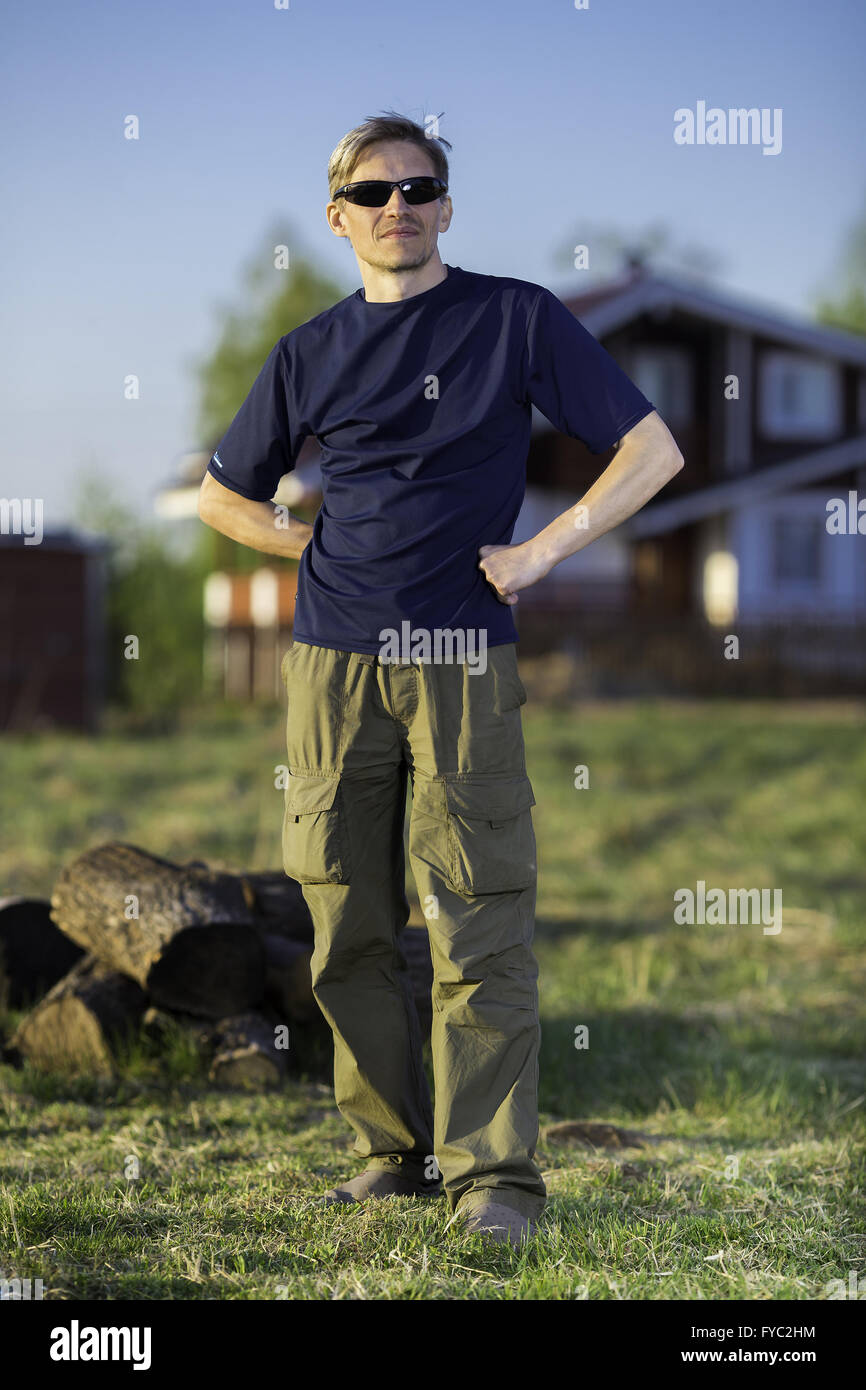Tough man in sunglasses standing with toy gun on natural background ...