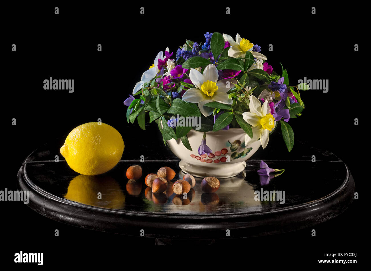 Lemon, nuts and flowers on a black background Stock Photo - Alamy