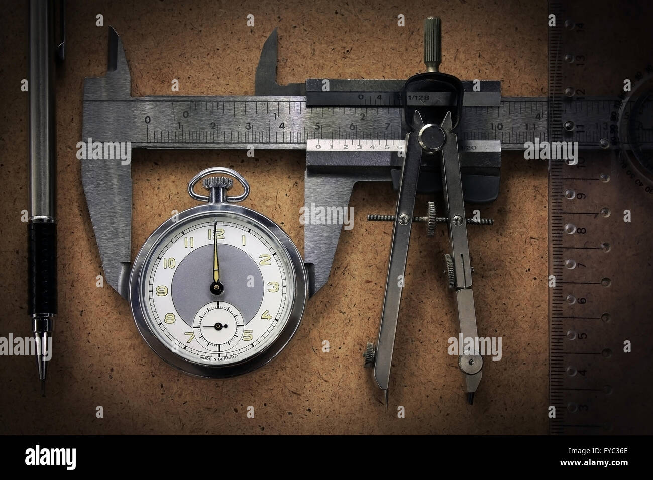 Pocket watch with engineering tools, pencil, calipers, ruler on wooden ...