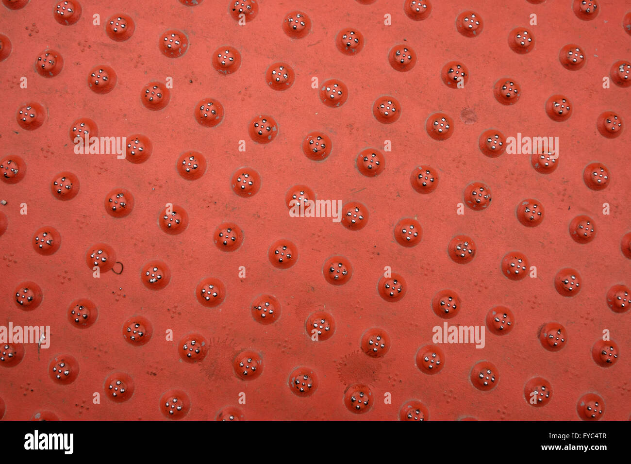 Red steel sidewalk plate with round pattern Stock Photo - Alamy