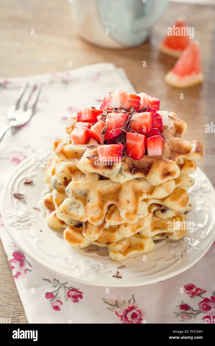 Strawberry waffles for breakfast served on white plate. Soft morning ...