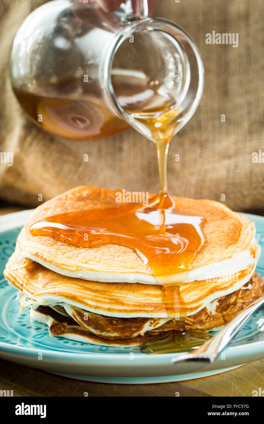 Pouring syrup over pancakes Stock Photo - Alamy