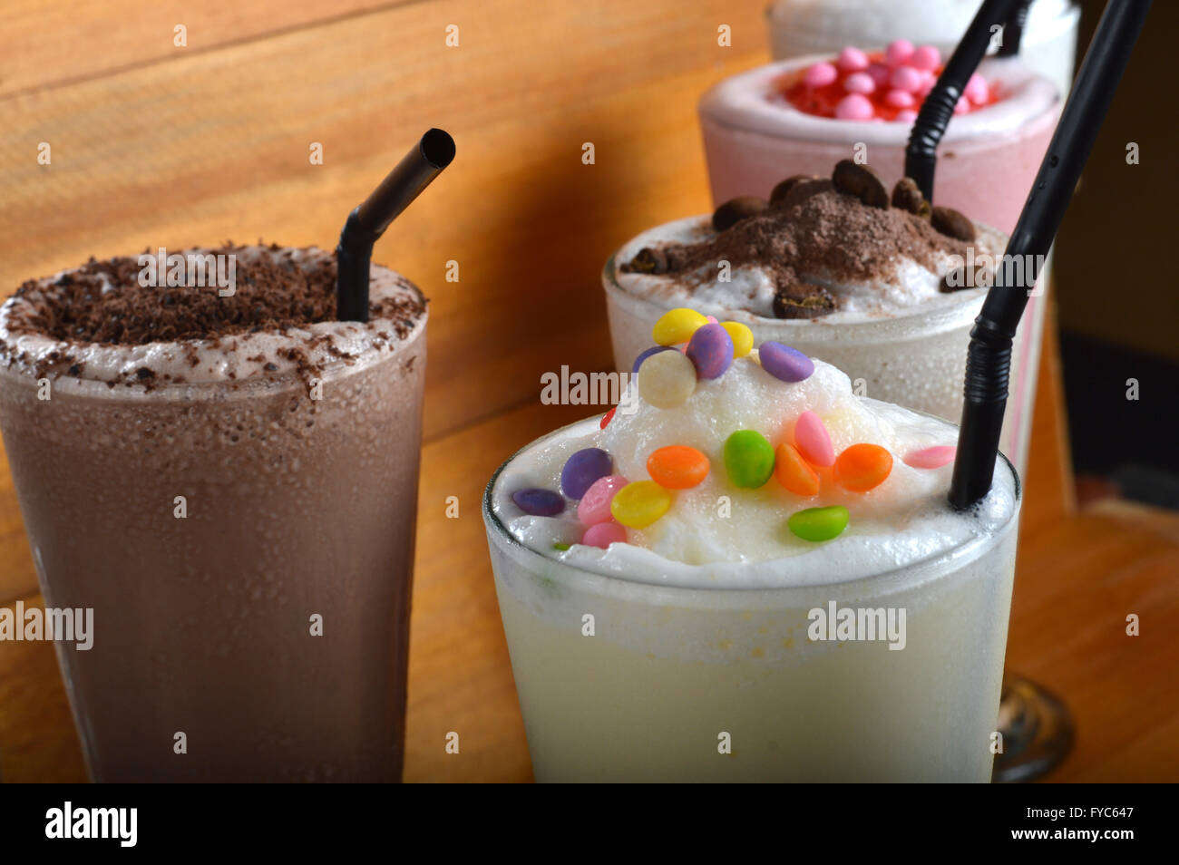 four types of milkshake drink on wooden board Stock Photo - Alamy