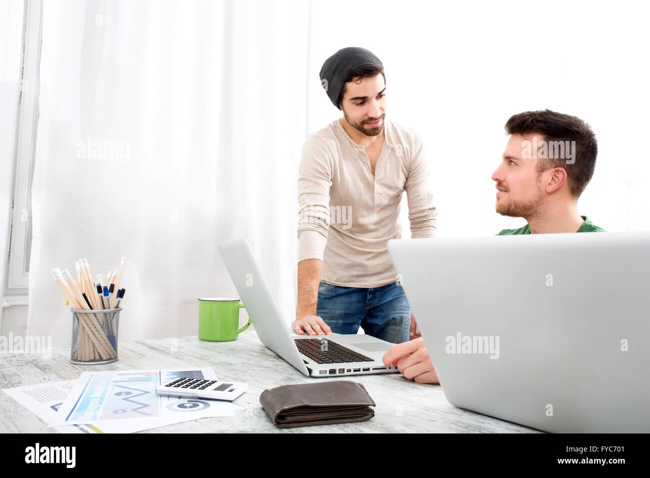 Two young colleagues discussing something in the office Stock Photo - Alamy