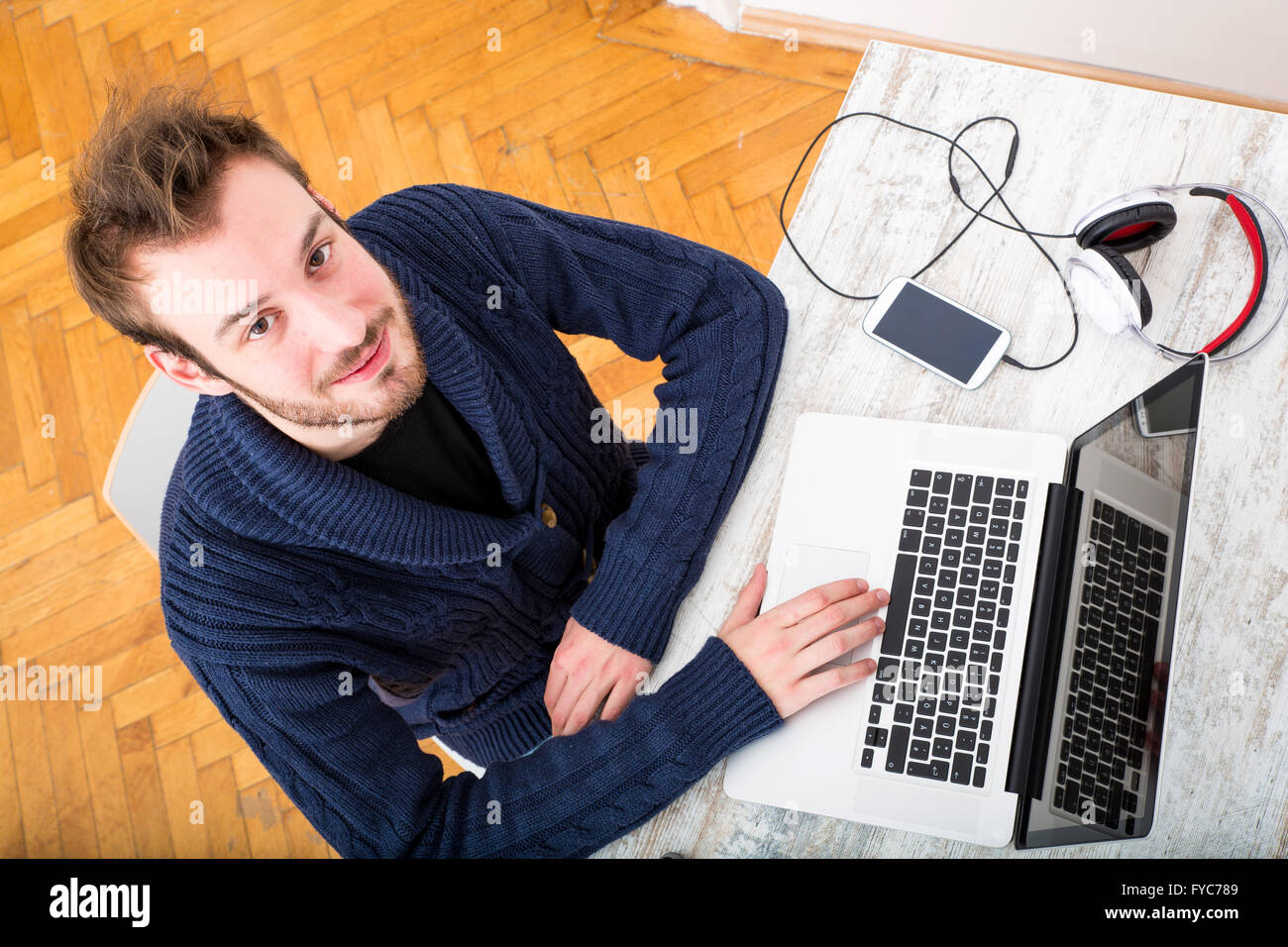 A young man working online from home with his laptop computer and ...