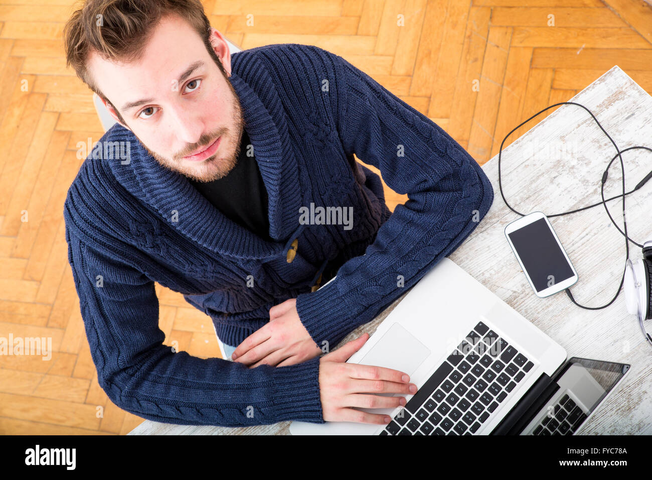 A young man working online from home with his laptop computer and ...