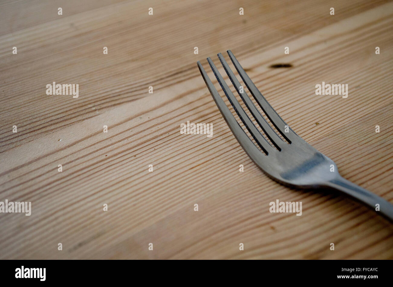 Fork on a wooden dining table Stock Photo - Alamy