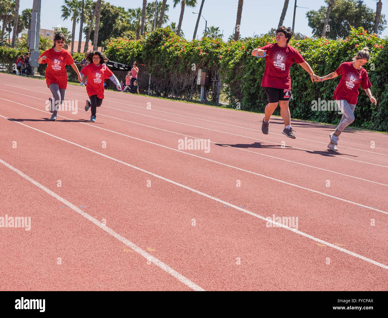 Adult helpers help disabled kids race in 50 meter race at the Southern ...