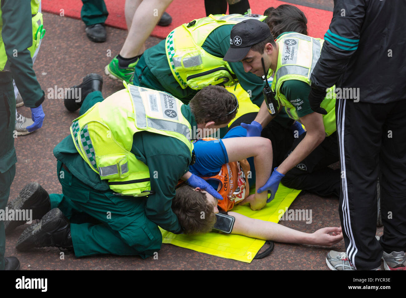 London, UK. 24 April 2016. Medics from St John Ambulance help a runner ...