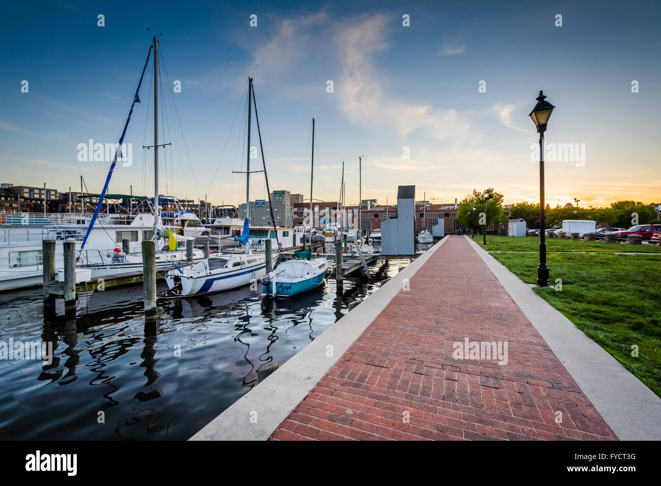 Waterfront promenade and boats docked in Fells Point, Baltimore ...