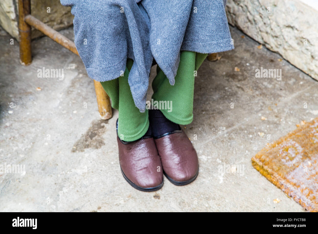 slippers of resigned man in blue gray room jacket sitting on an old ...