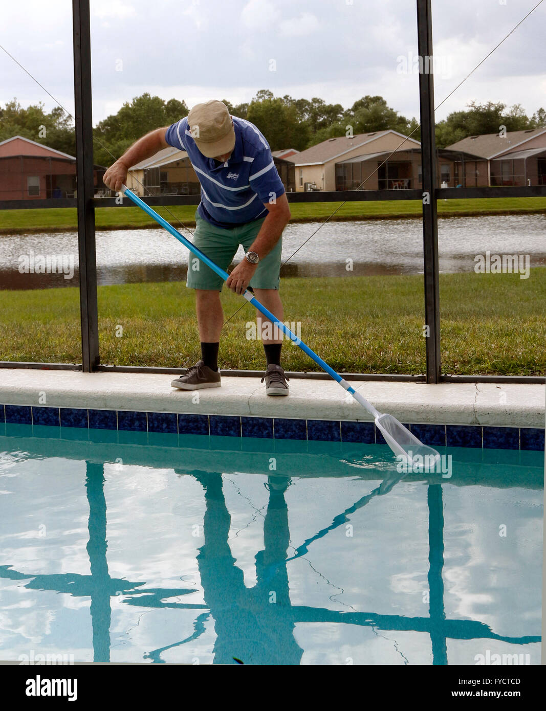 Mature man doing pool maintenance to his Florida pool home, 25th April ...