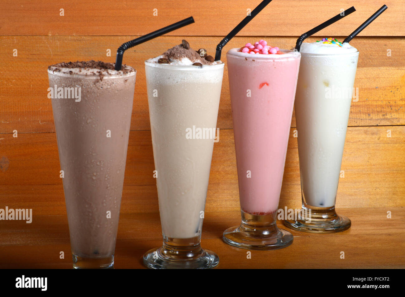 four types of milkshake drink on wooden board Stock Photo - Alamy