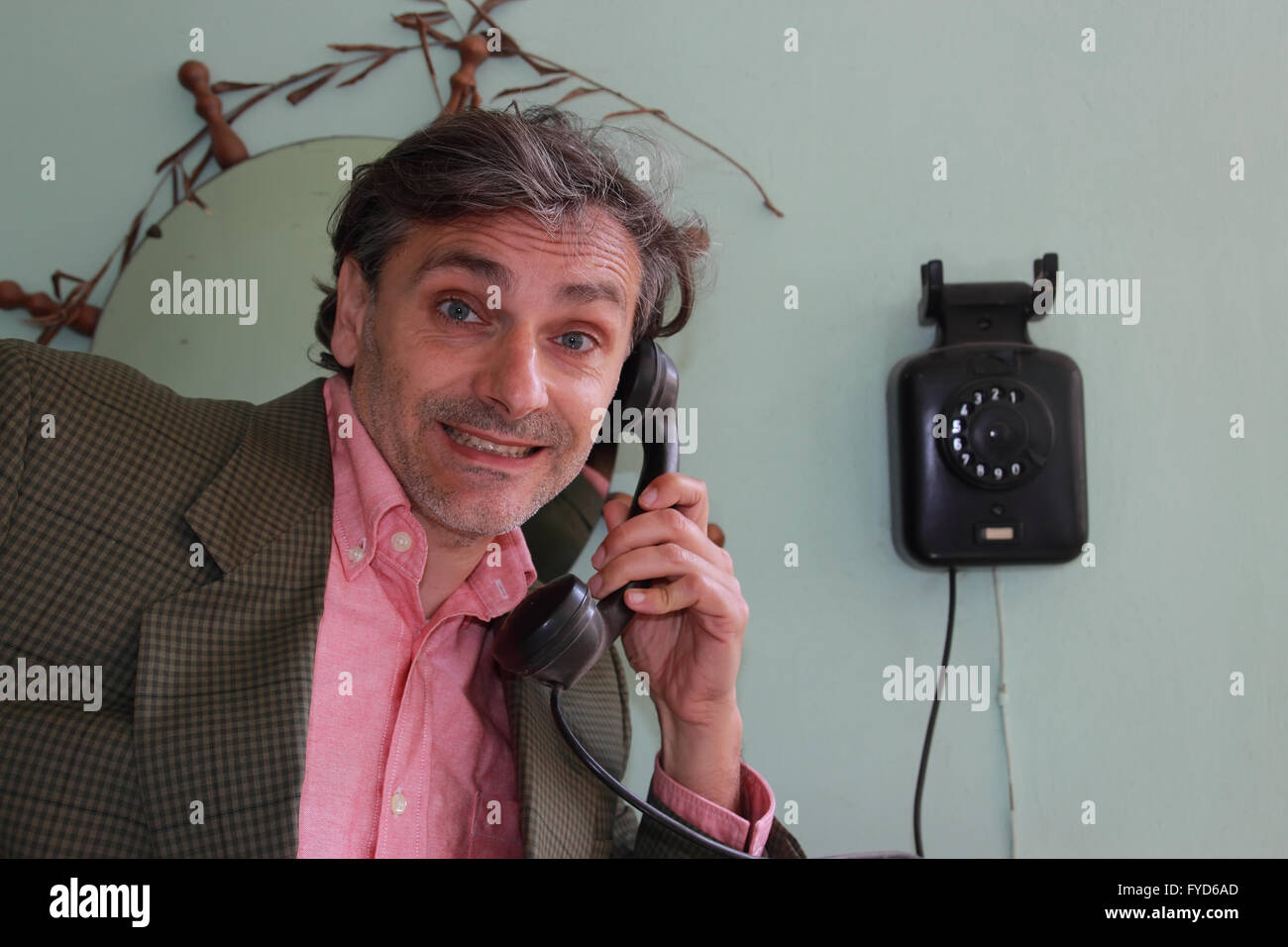 smiling man answering an old fashioned telephone Stock Photo - Alamy