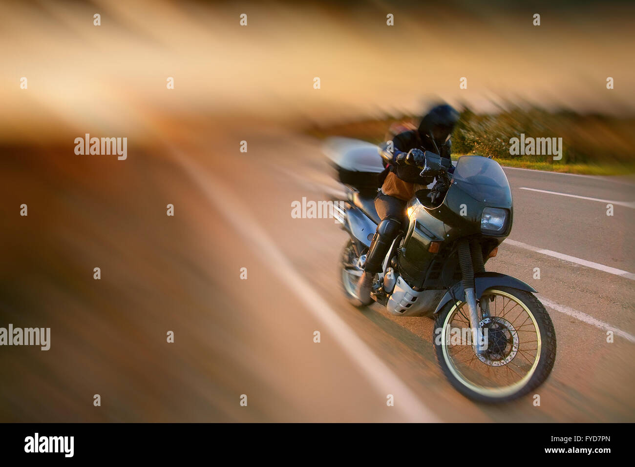 Biker and motorcycle on the road at sunset Stock Photo - Alamy