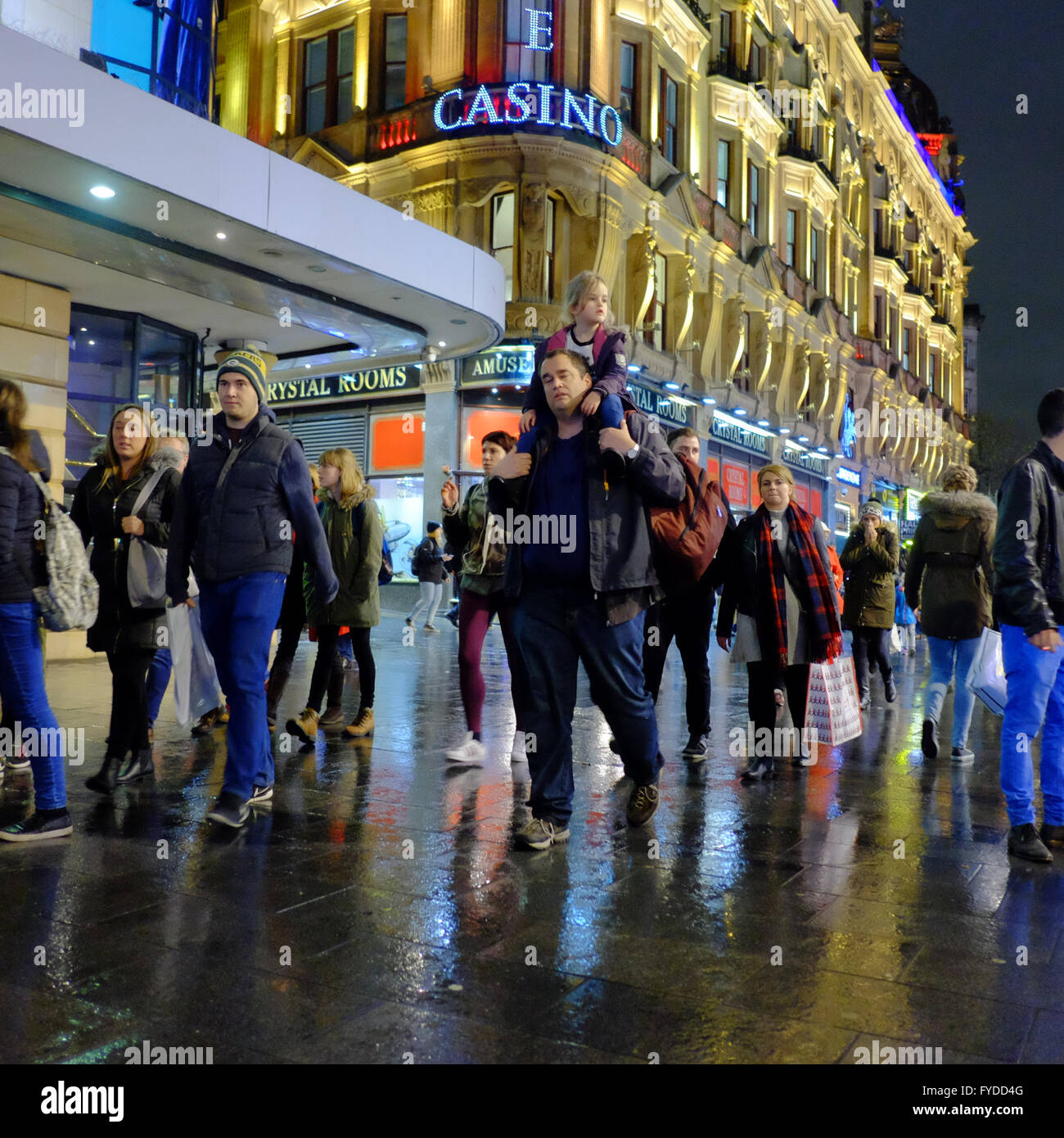 Man looking tired with young girl on his shoulders walking on wet ...