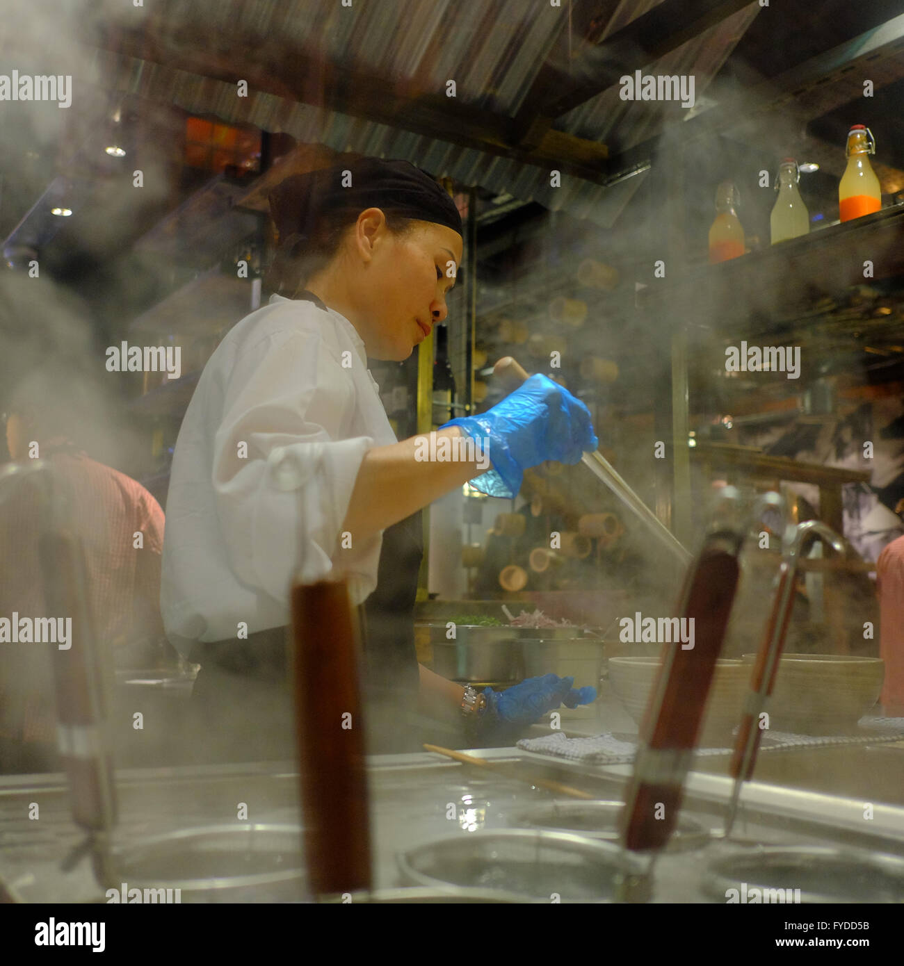 Female Chef cooking food in steamy Chinese Restaurant in China Town ...