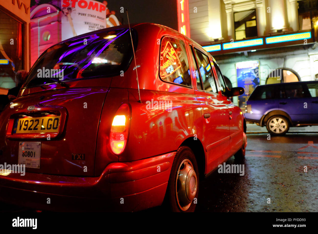 Red Taxi stopping outside The IVY Restaurant with Ambassadors Theater ...