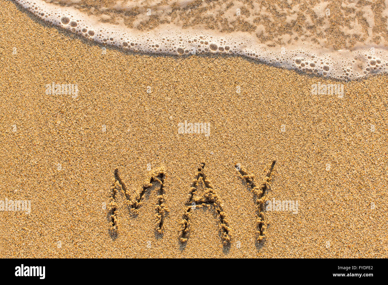 May - word drawn on the sand beach with the soft wave. Months series of ...