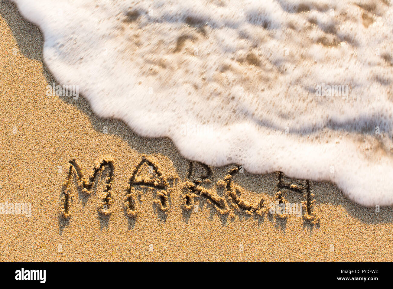 March - word drawn on the sand beach with the soft wave. Months series ...