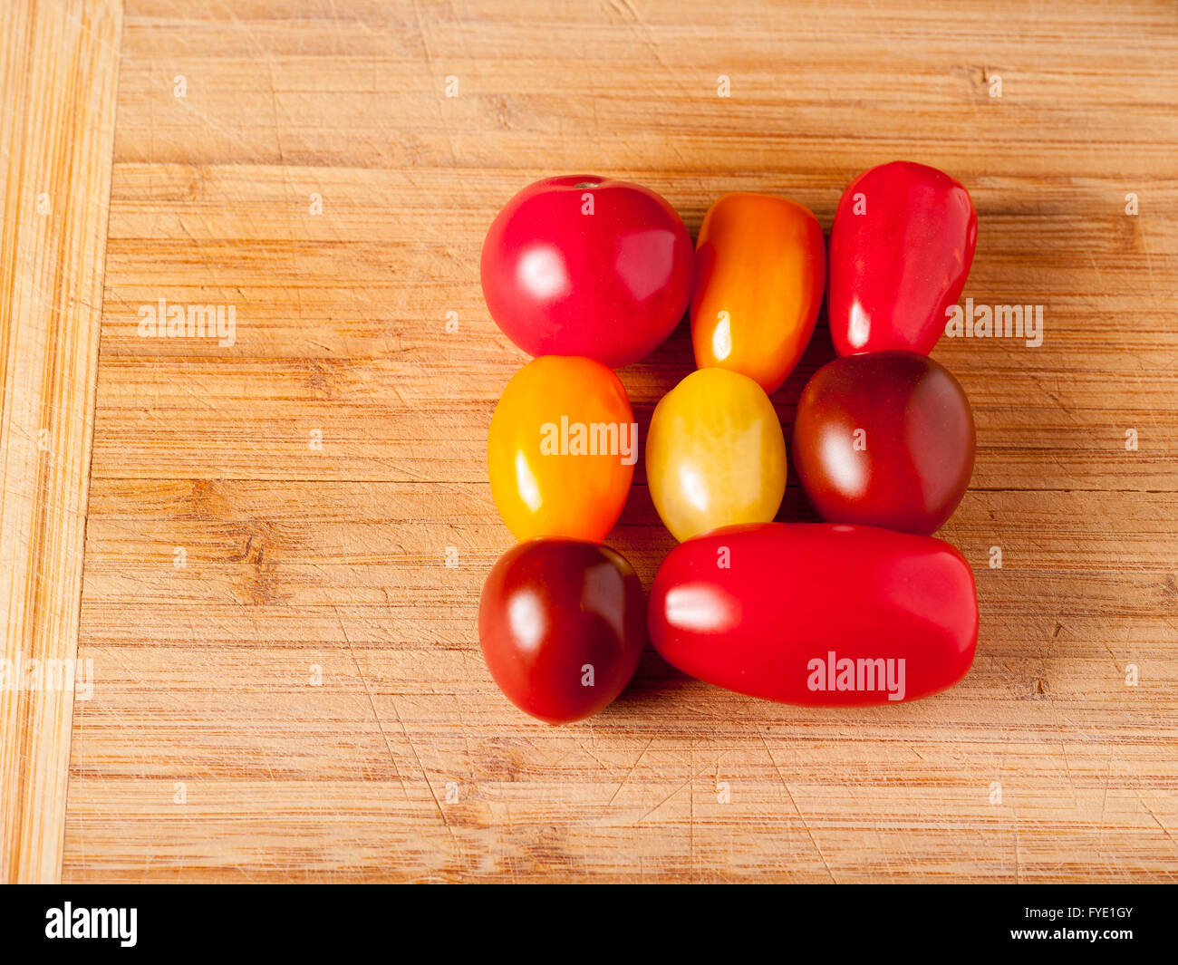 Mini gourmet tomatoes of different types and colors on a wooden ...