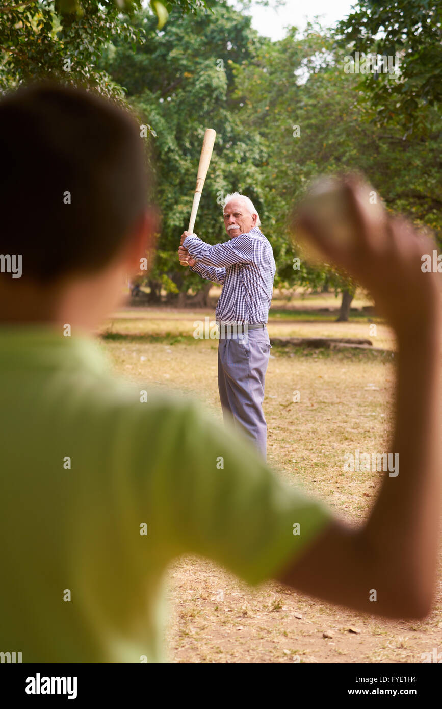 Grandparents spending time with grandson: Senior man playing baseball ...