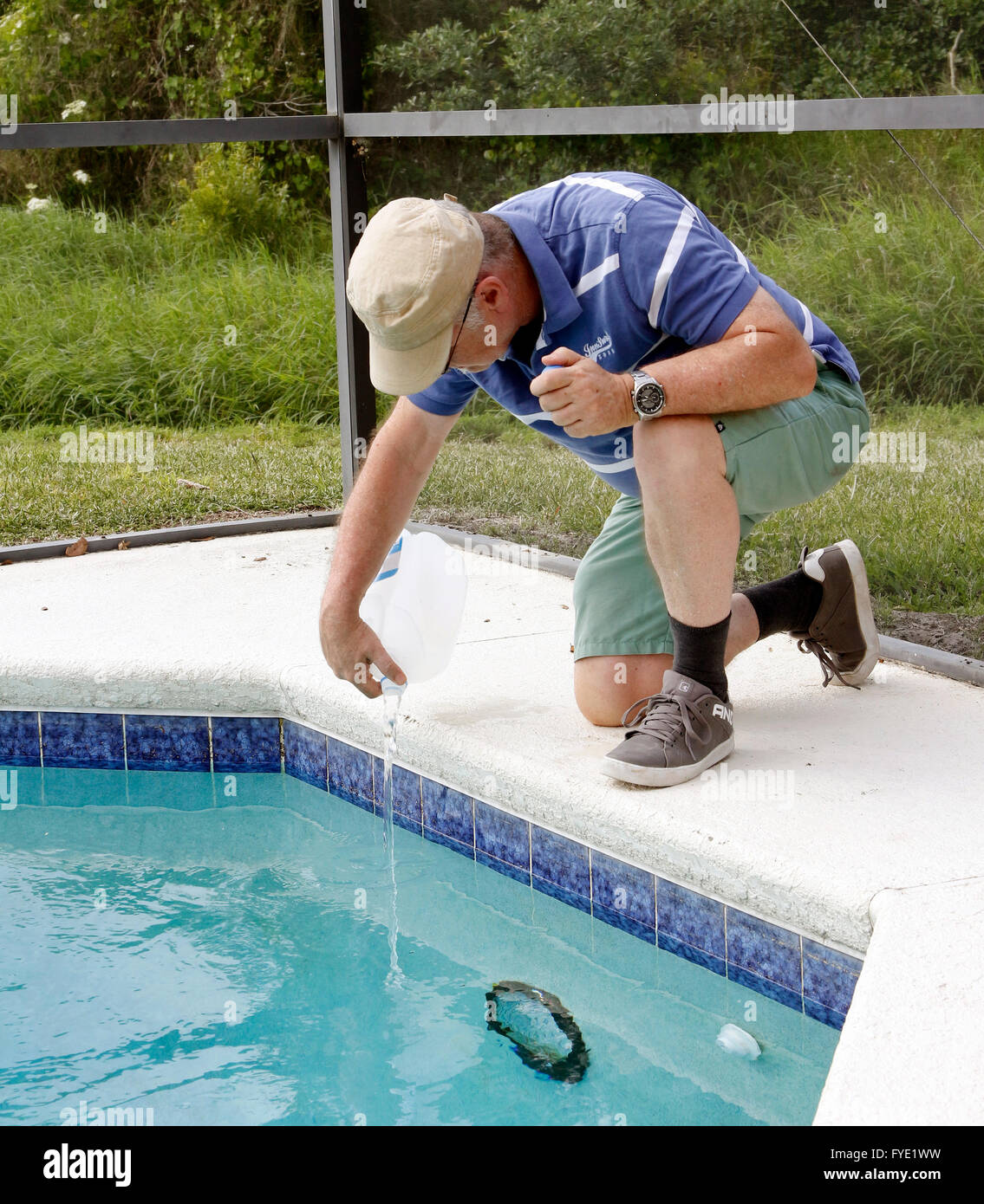 Mature man doing pool maintenance to his Florida pool home, 25th April ...