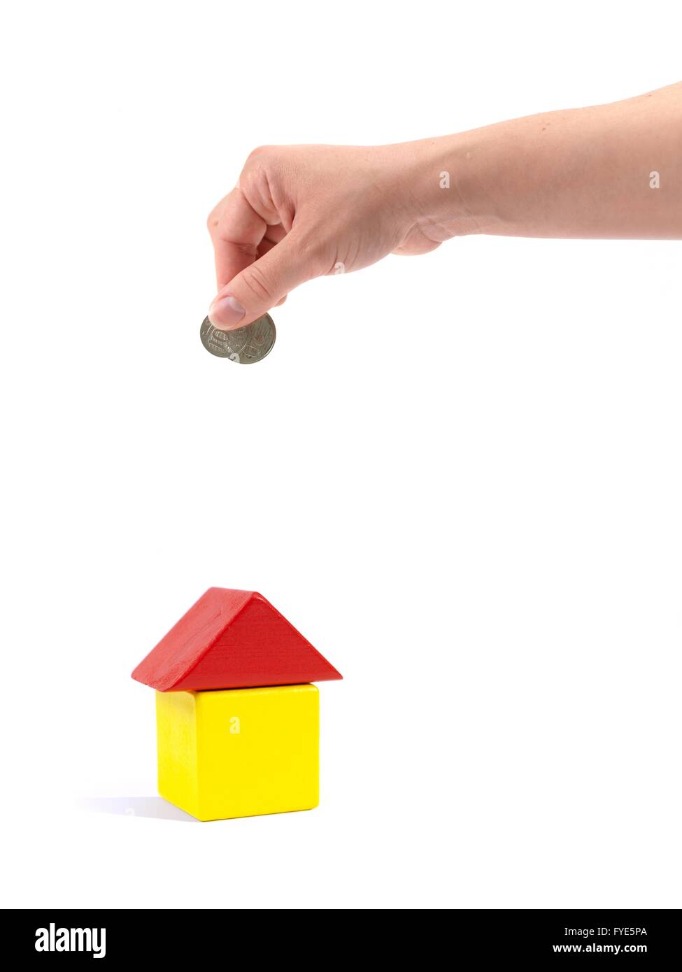 A female hand with coin and a toy house isolated against a white ...