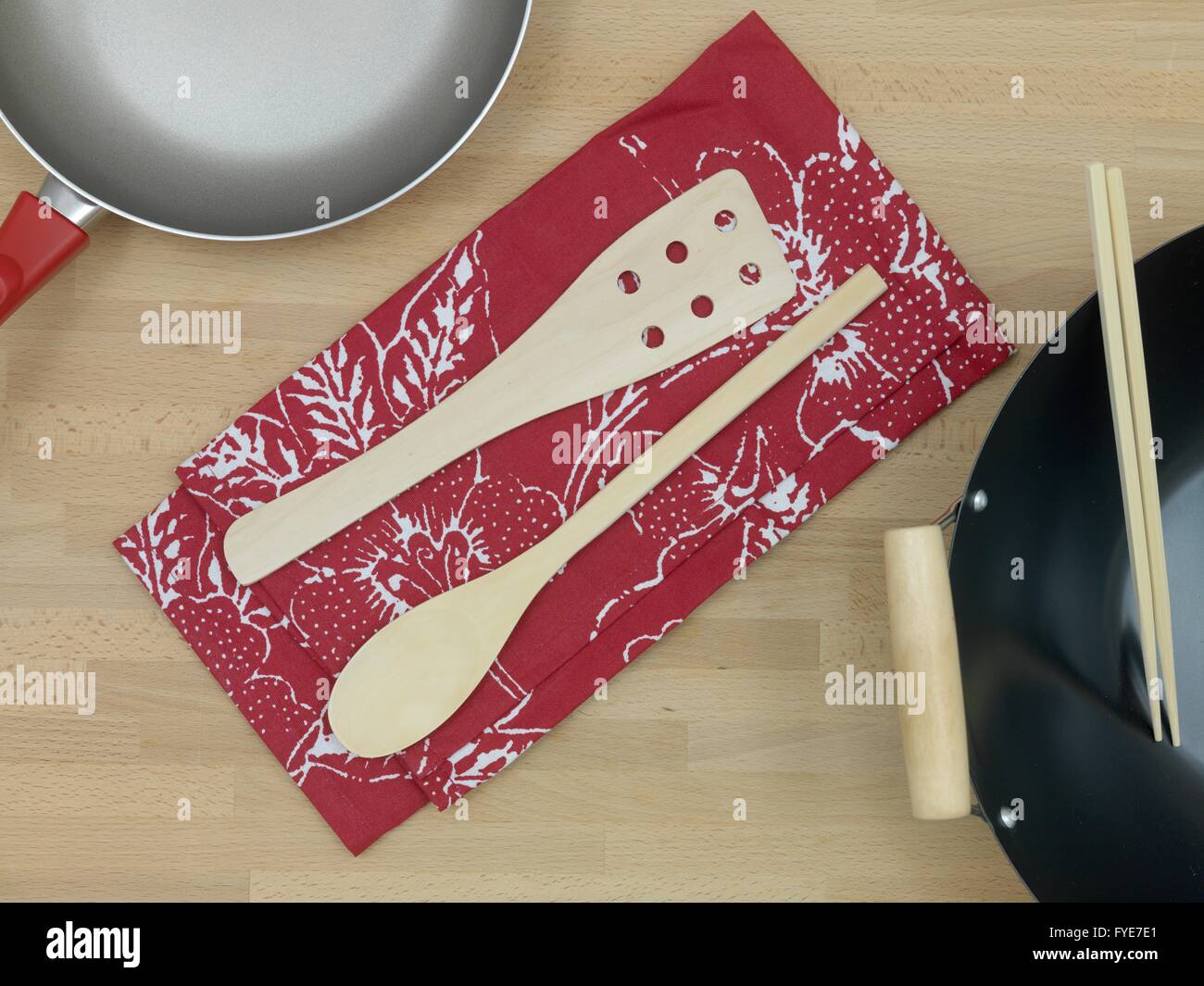 A wok and frying pan on a wooden kitchen bench Stock Photo - Alamy